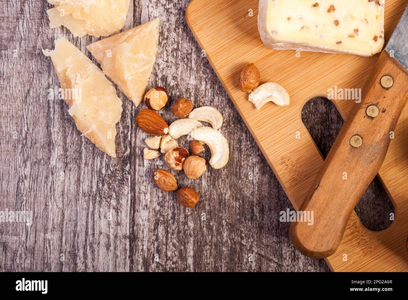 Different type of cheese and nuts on wooden background in close up ...
