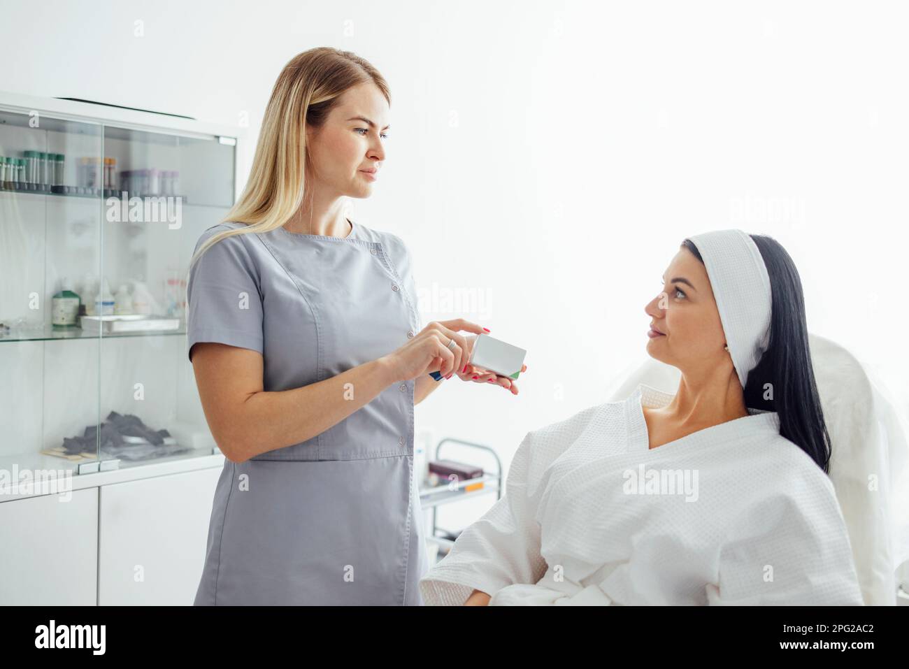 Pretty caucasian beautician communicates with her female client. Beauty ...