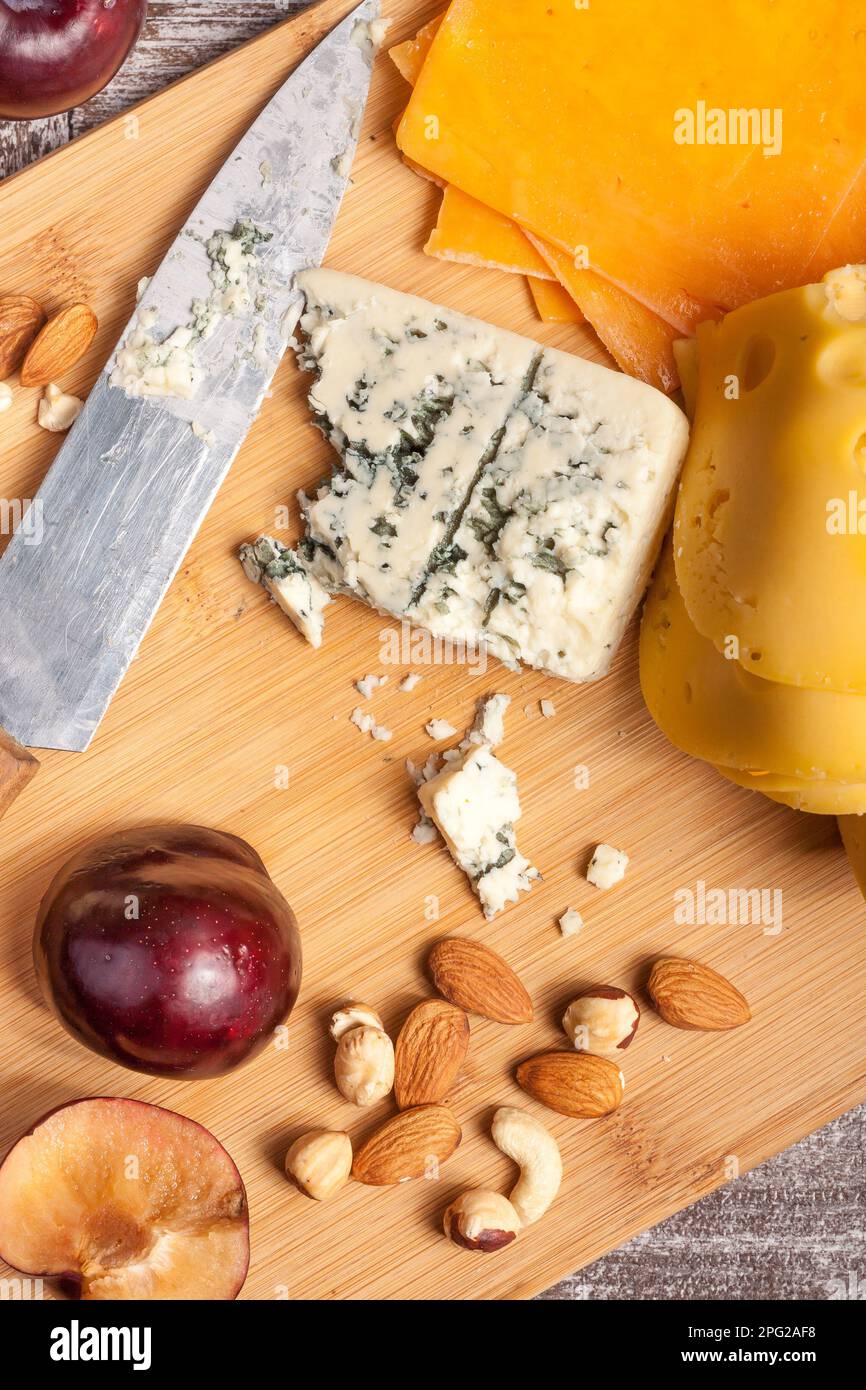 Cheese with nuts and fruits on wooden background. Over top view Stock ...