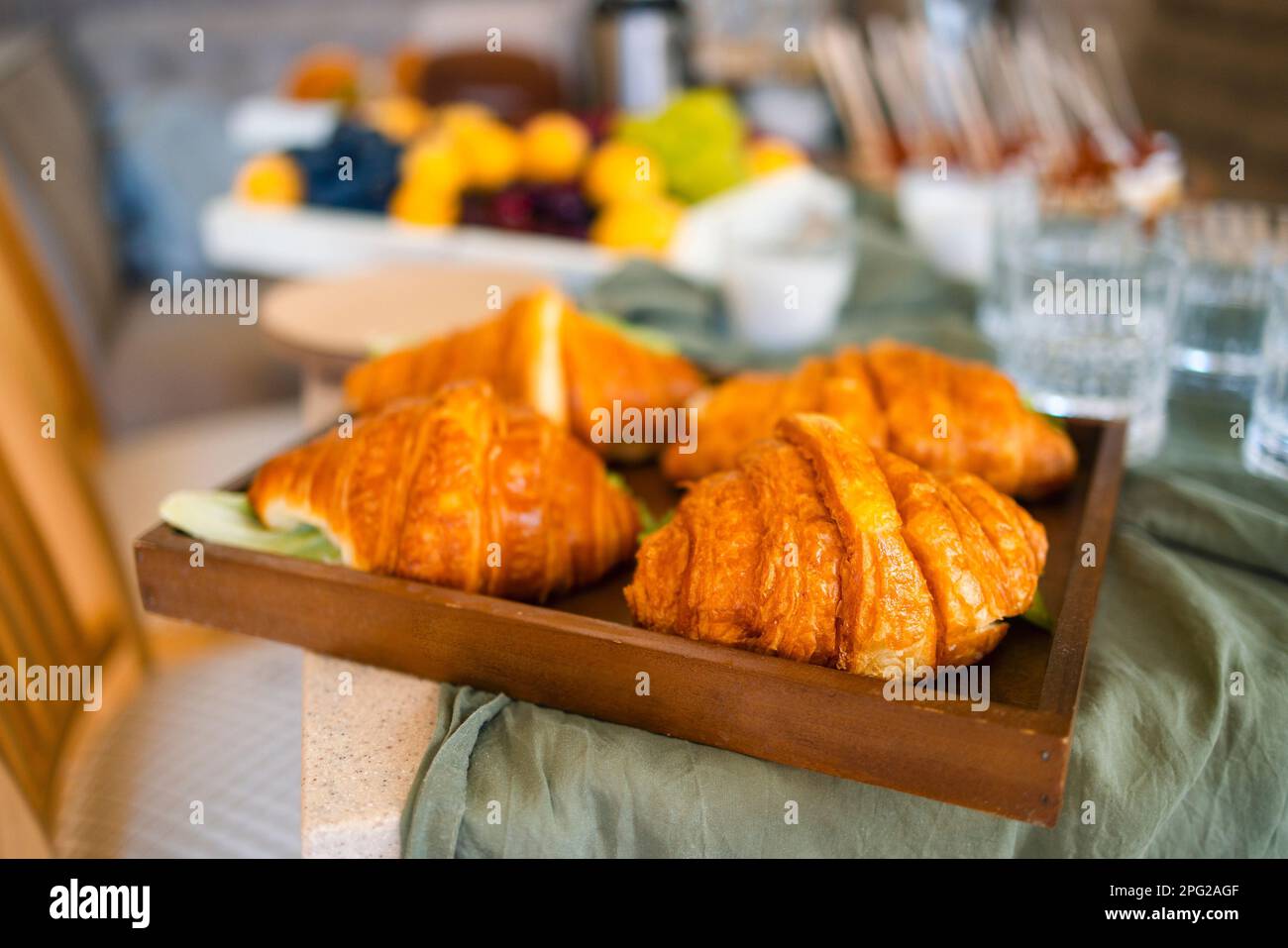 Swiss table at the party. Close up of croissants with greens and ...