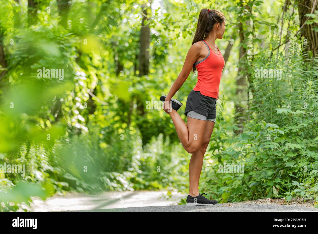 Fit stretch woman stretching quad leg muscle standing getting ready to ...