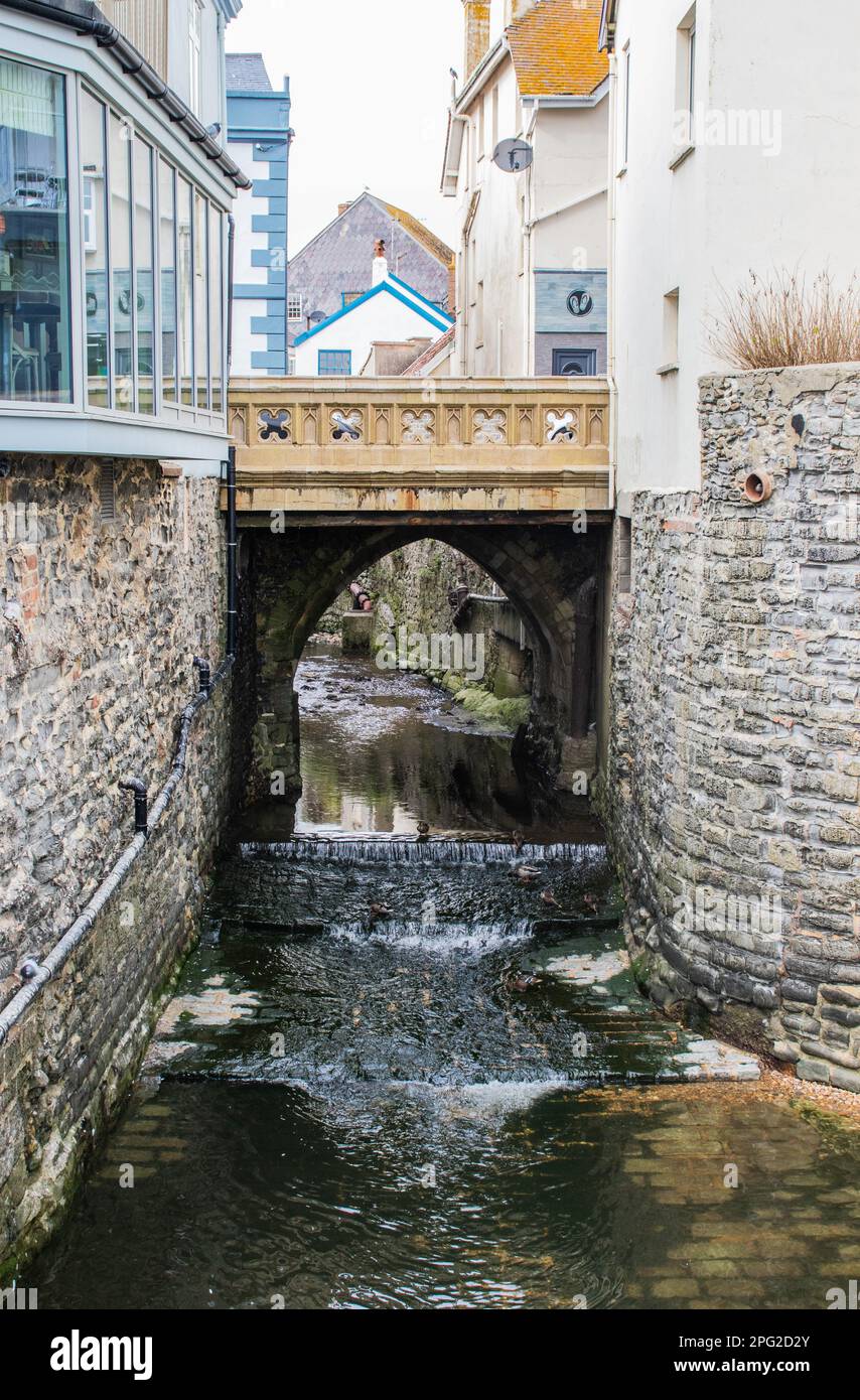 A river channel flows through the town of Lyme Regis in Dorset under a ...