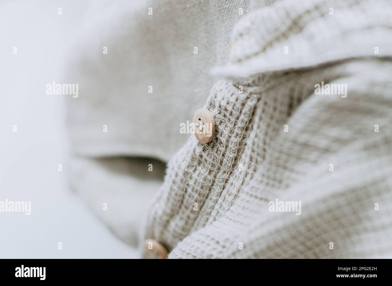 Close up wooden button on waffle linen shirt Stock Photo - Alamy