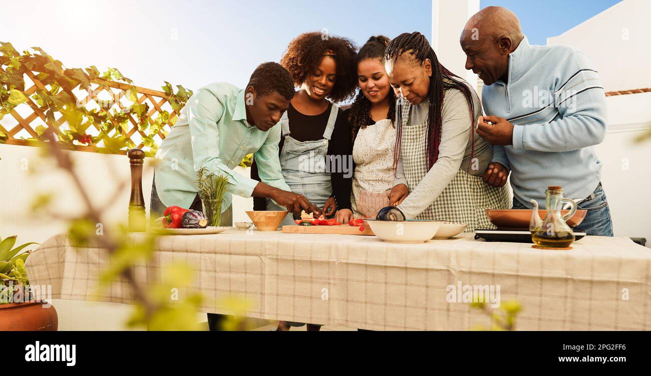 Happy african family cooking together during summer time at home patio ...