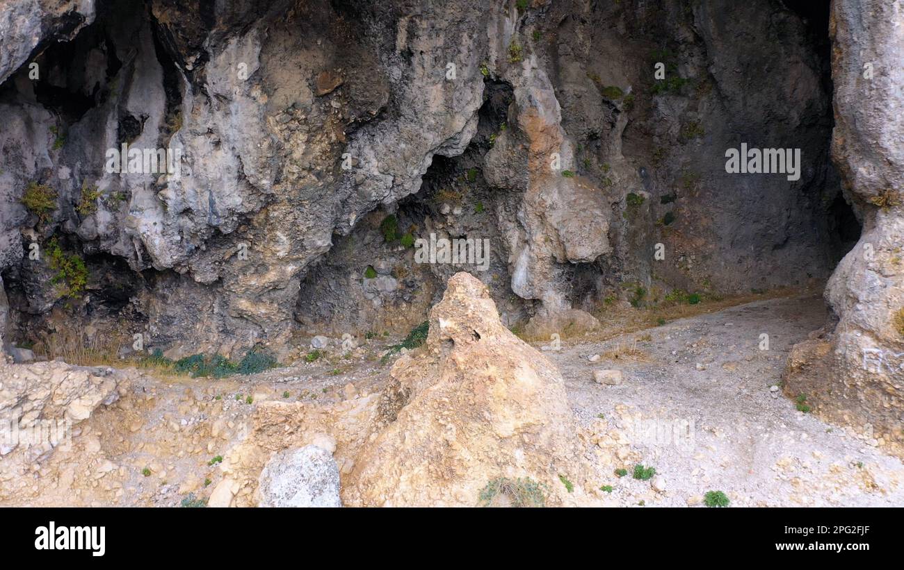 Huge rock formation with a hole in it. Cave in rocky mountain close up ...