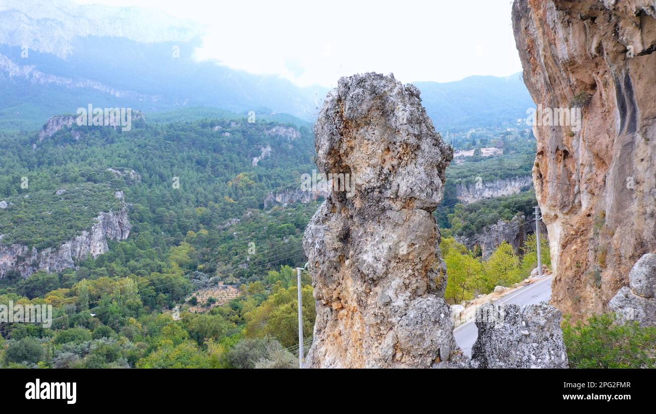 Rocky cliff on the background of green mountain valley. Scenic rocky ...
