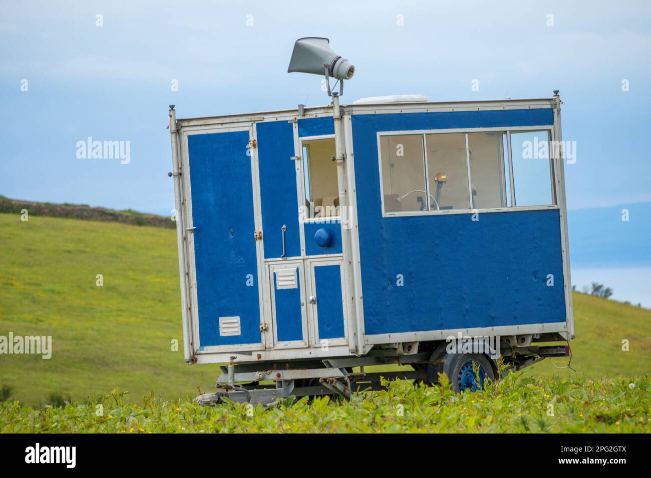 Blue commentators box in the middle of a field with megaphone attached ...