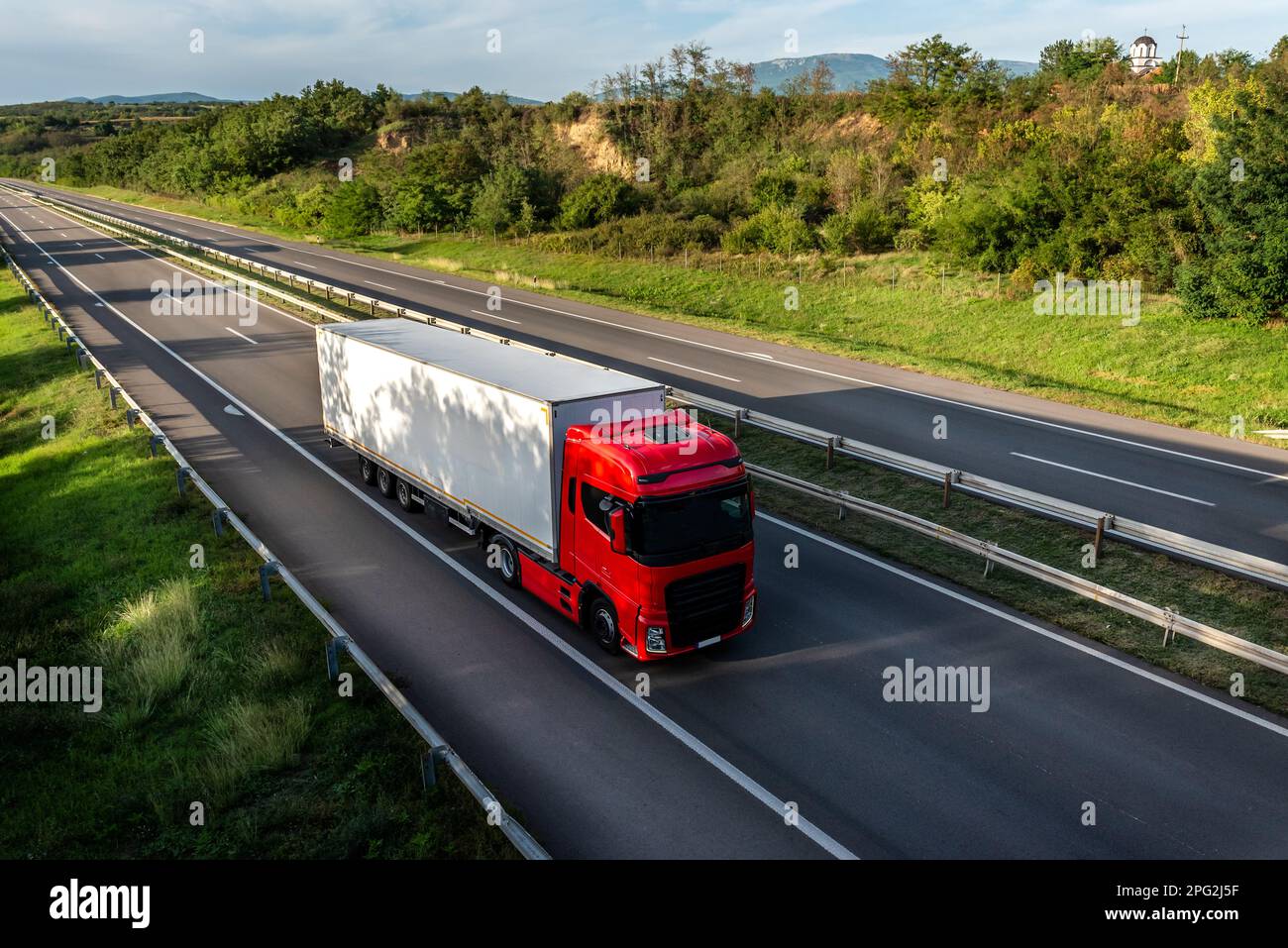Big Red Transportation Truck on a highway road through the countryside ...
