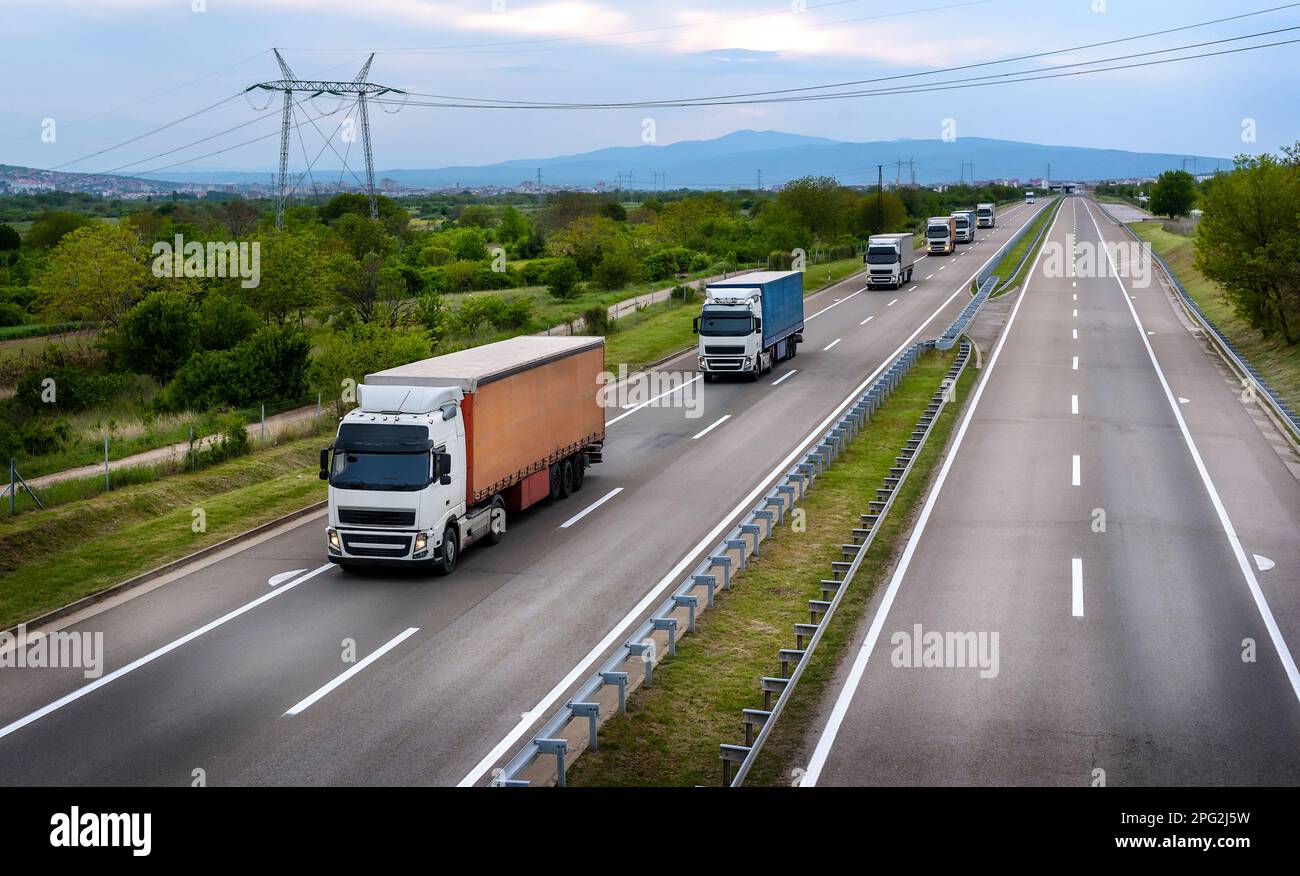 Long Convoy of Trucks with containers on highway, cargo transportation ...
