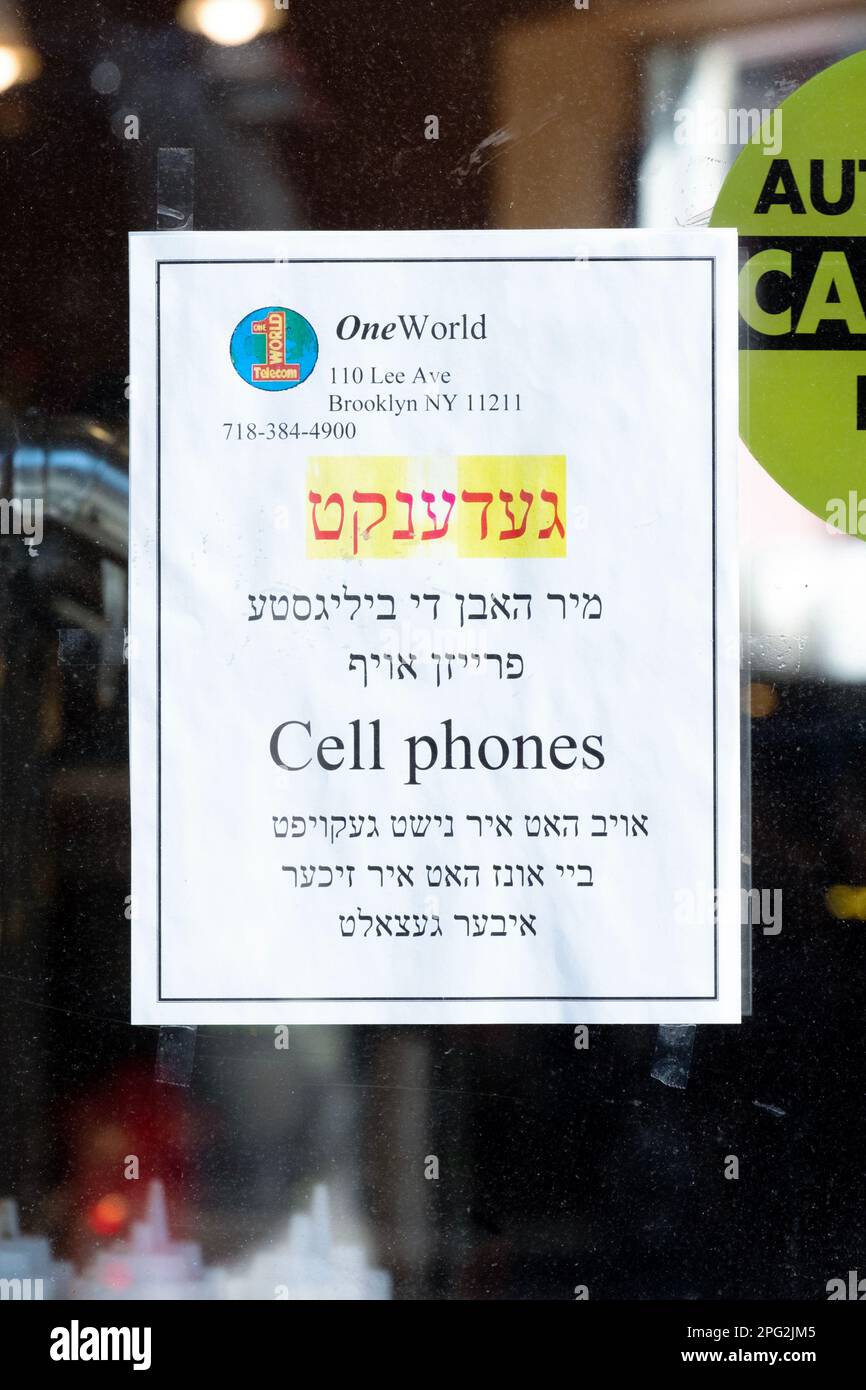 A bilingual sign in a bakery window advertising for low priced cell ...