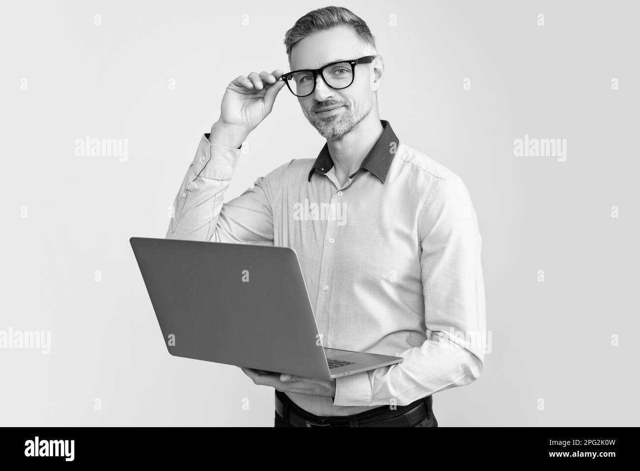 mature entrepreneur in eyeglasses working on computer on grey ...