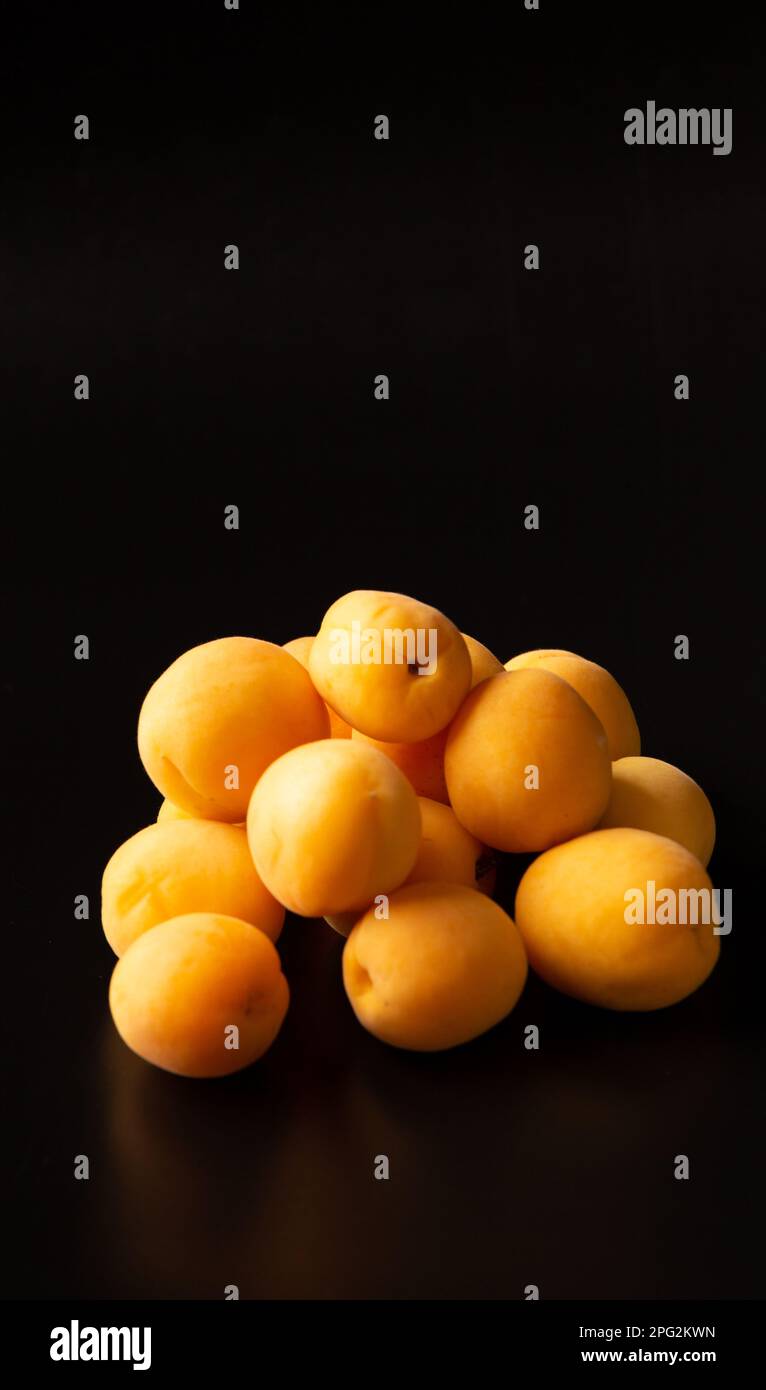 Apricots on a black background. A handful of apricots on a dark ...