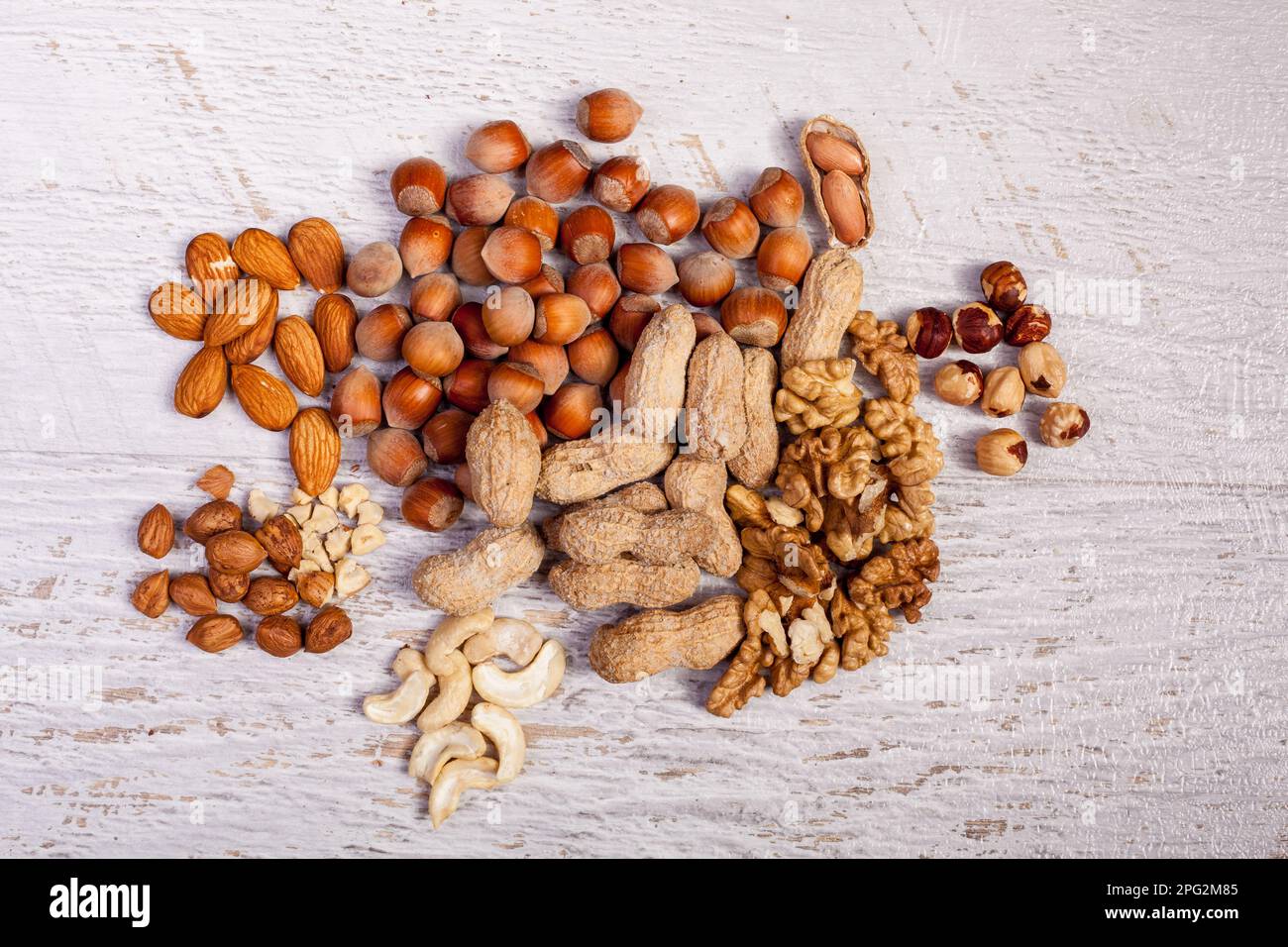 Different type of nuts of white wooden background. Healthy food Stock ...