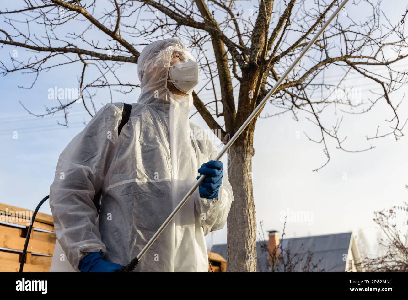 Using chemicals in the garden orchard gardener applying an insecticide ...