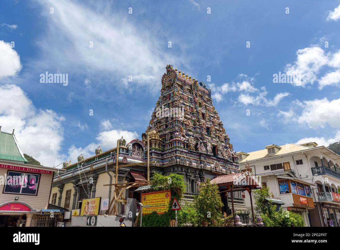 Antique Hindu temple framed by cityscape with bustling shops in ...