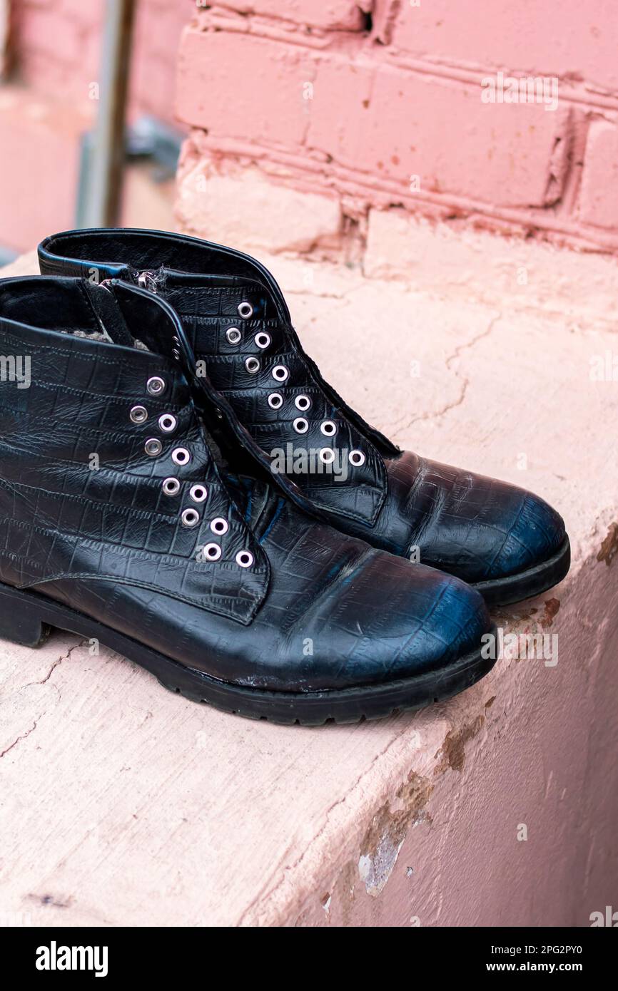 Old black discarded boots in a landfill close up Stock Photo - Alamy