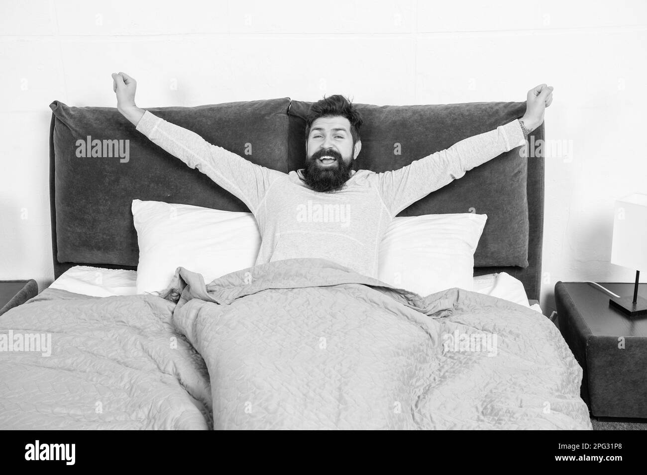 Happy man smiling and stretching in bed waking up after sleep, morning Stock Photo - Alamy