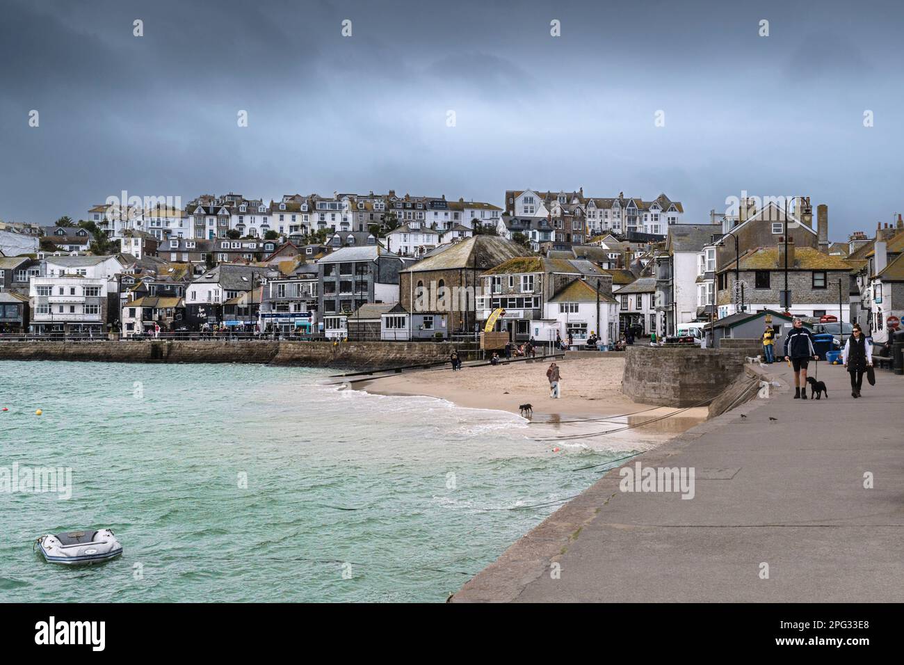 UK weather. Visitors sitting on a bench on a rainy chilly miserable day ...