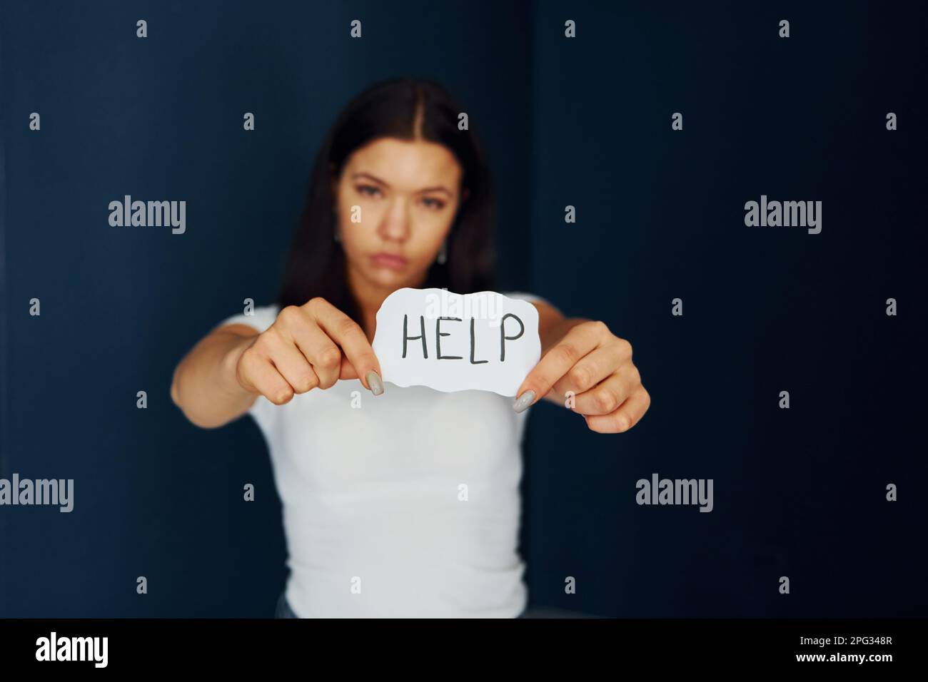 Young scared woman holds sign and ask for help. Conception of domestic ...