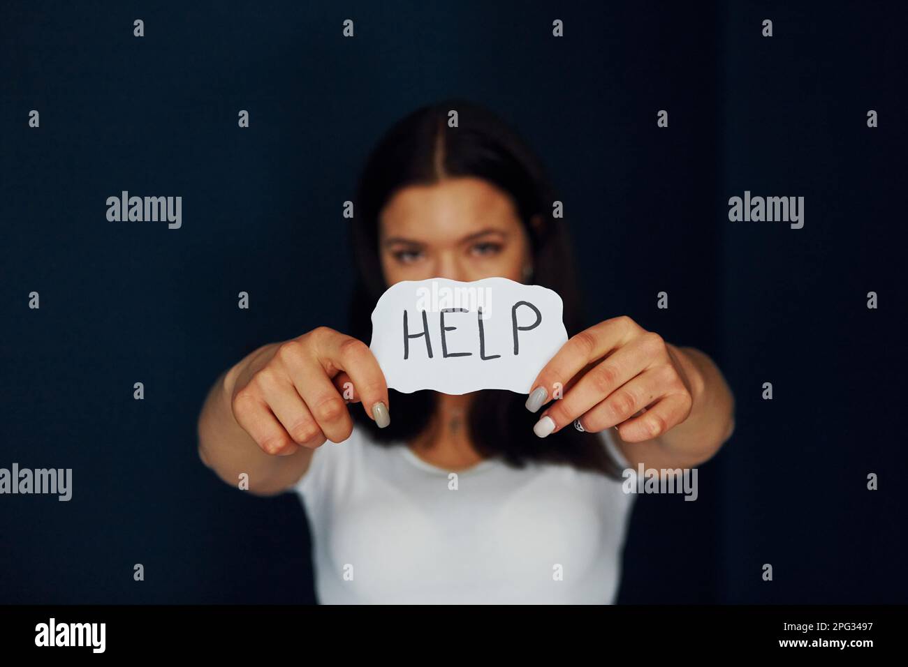 Young scared woman holds sign and ask for help. Conception of domestic ...