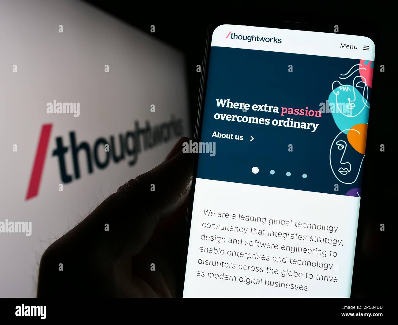 Person holding smartphone with website of US software company Thoughtworks Inc. on screen in ...
