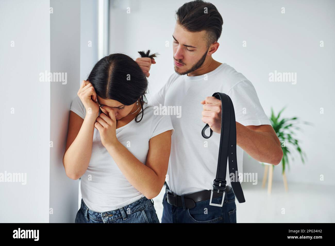 Violent aggressive young man with belt threatening his girlfriend at ...