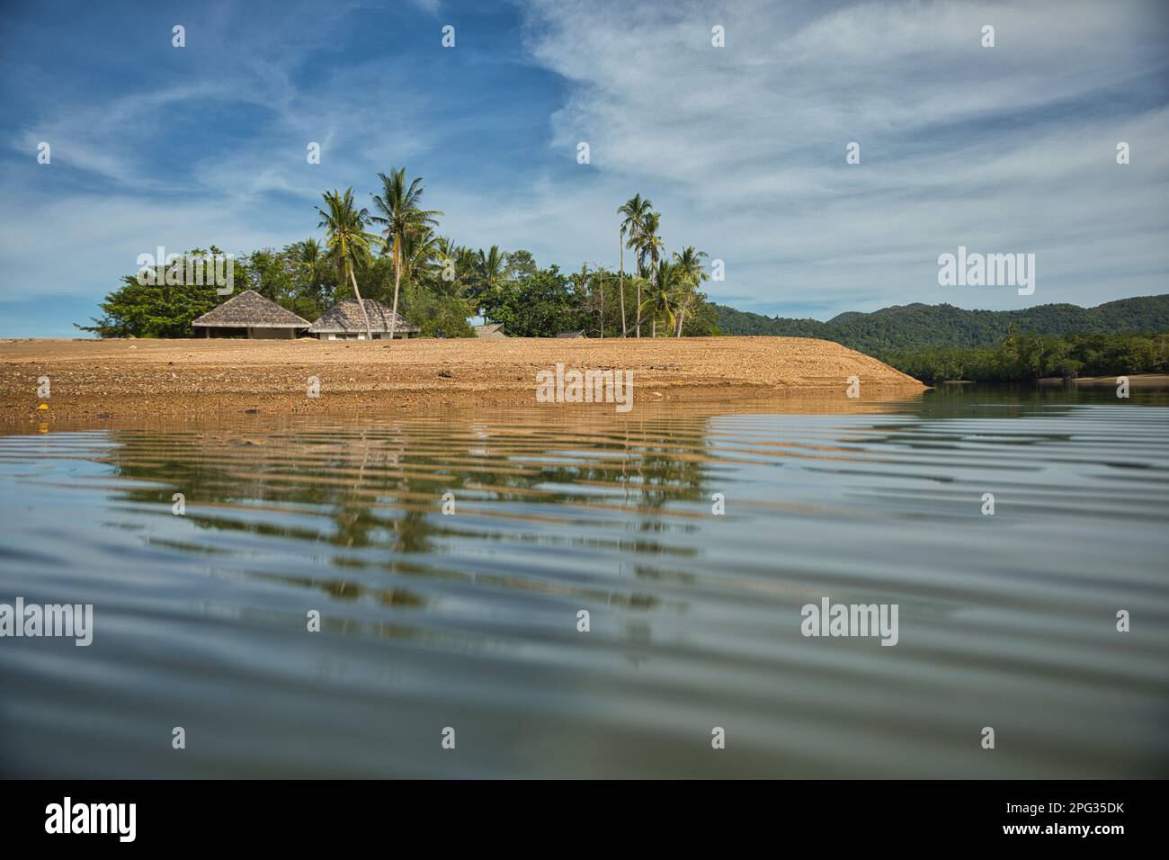 Wide sandy beach in Coron, Philippines with palm trees and huts behind ...