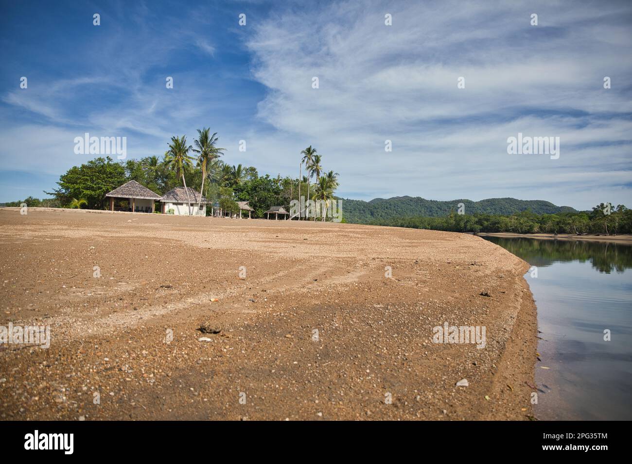 Wide sandy beach in Coron, Philippines with palm trees and huts behind ...