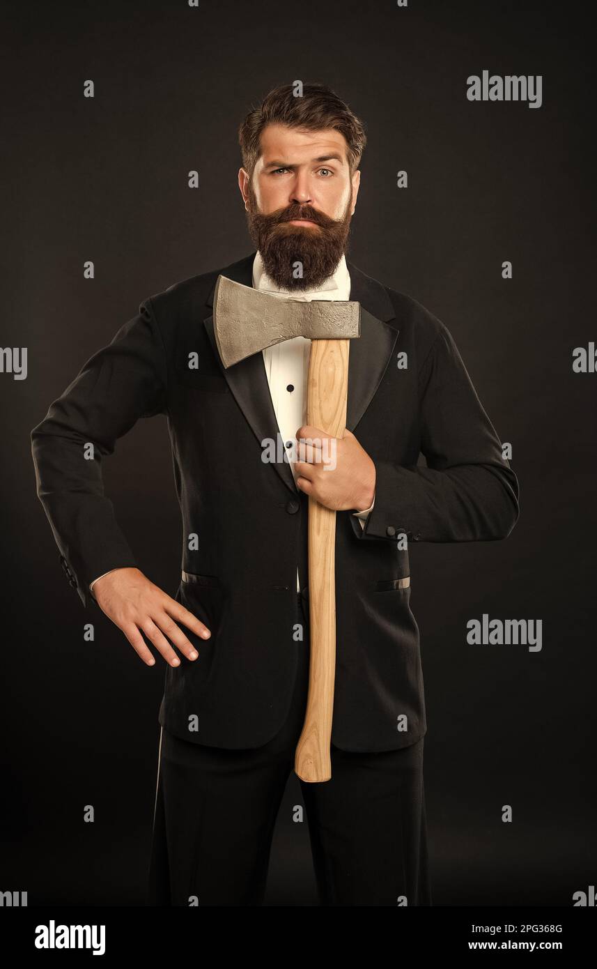 Serious bearded man in suit holding axe dark background, barbershop ...