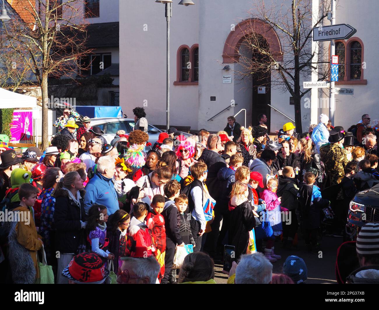 A group of people at a parade event wearing brightly-colored clown hats ...