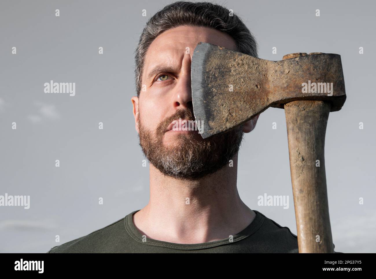 confident man cover face with axe. caucasian man hold ax. brutal man on ...