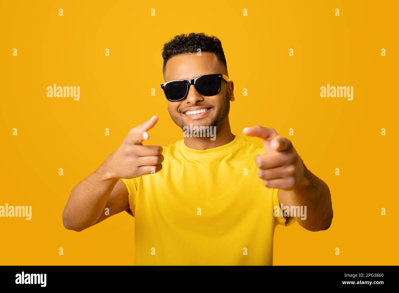 Hey you. Excited positive young arab man in sunglasses pointing fingers ...