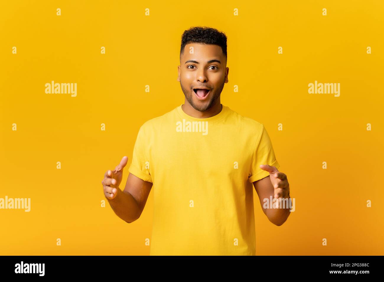 Excited surprised Indian man holding hands in front of him, presenting ...