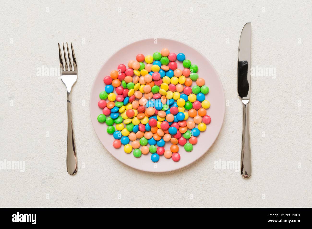 cutlery on table and sweet plate of candy. Health and obesity concept ...