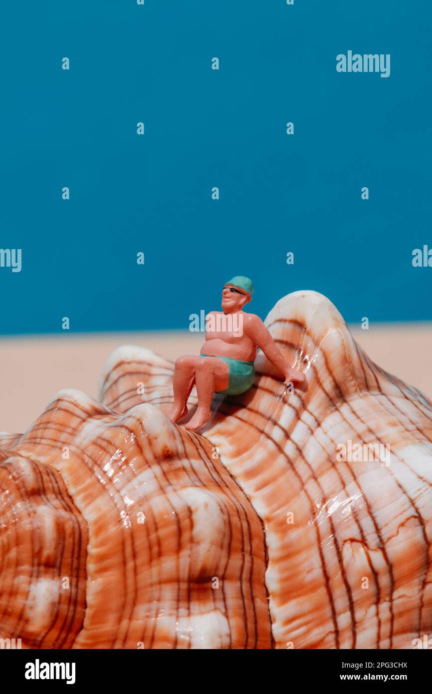 closeup of a miniature man, in a green swimsuit, wearing a green cap ...