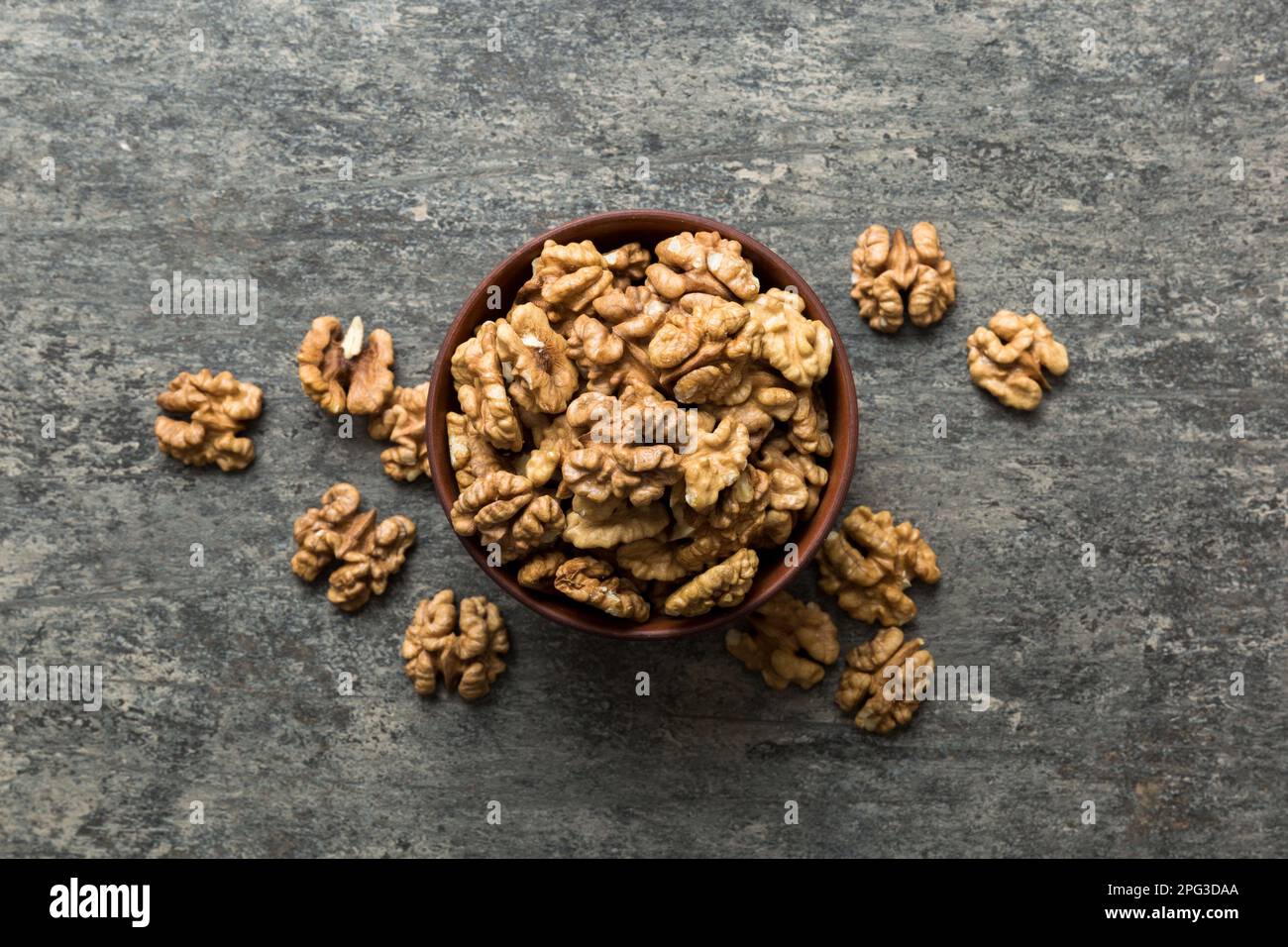Fresh healthy walnuts in bowl on colored table background. Top view ...