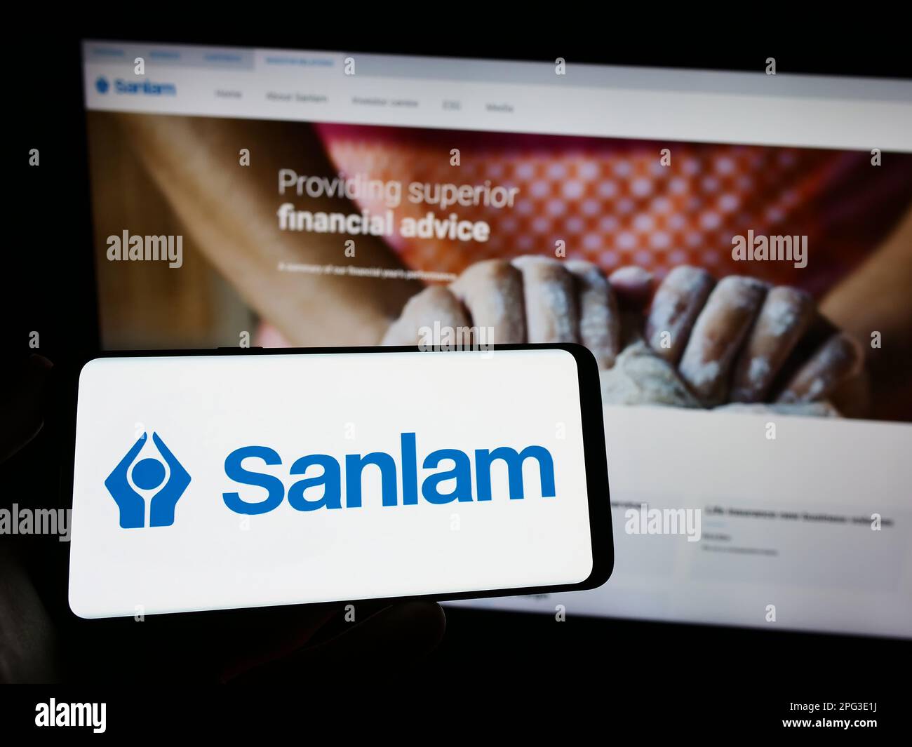 Person holding mobile phone with logo of South African financial ...