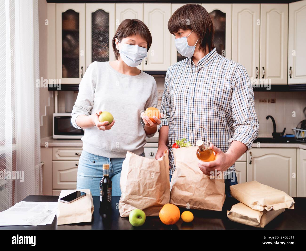 Young couple in protective masks is sorting out purchases in the ...