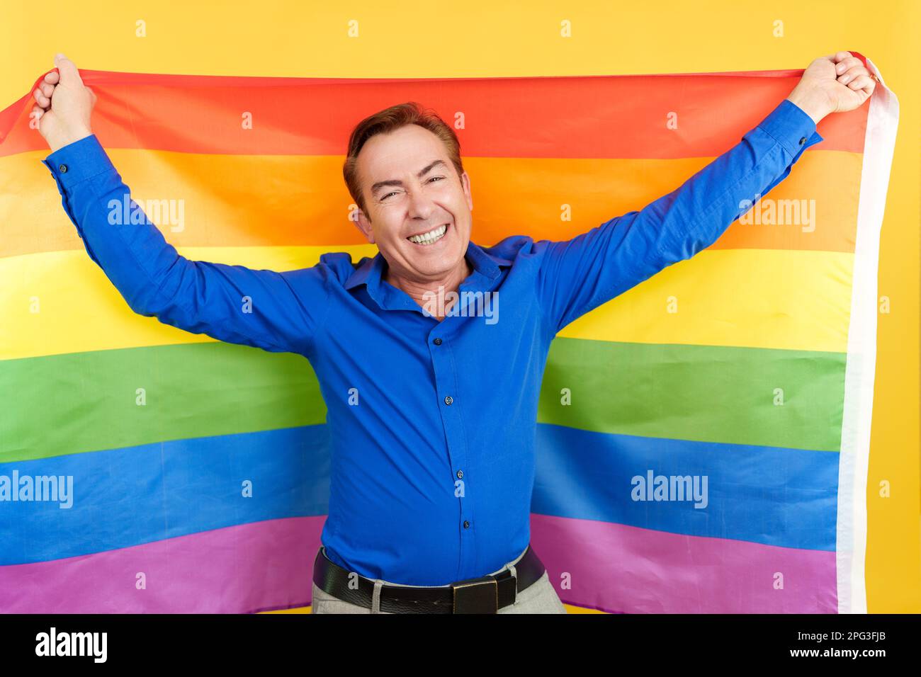 Happy mature man raising a lgbt rainbow flag Stock Photo - Alamy
