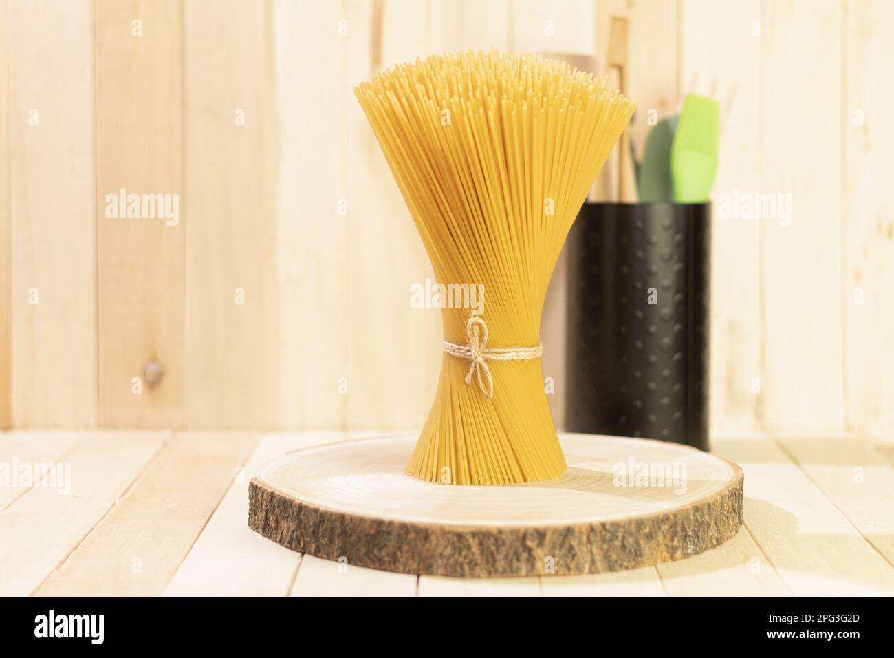 A bunch of dry spaghetti pasta in a stack horizontally. A pile of raw ...