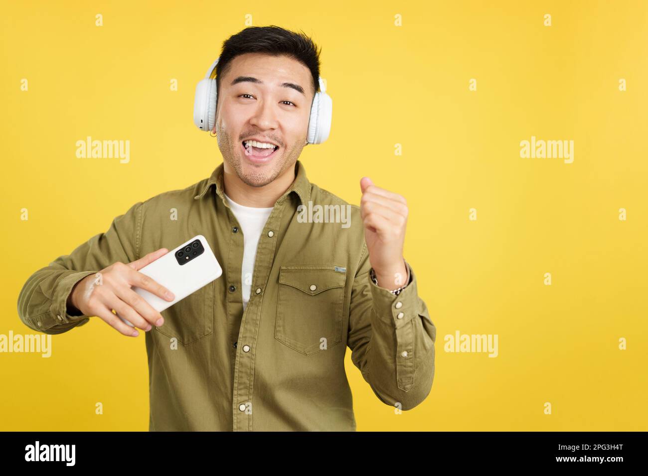Happy chinese man dancing and listening to music with mobile Stock ...