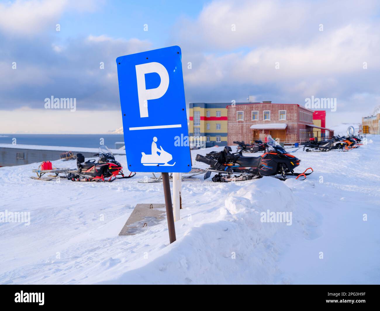 Parking for snow mobiles. Russian coal mining town Barentsburg at fjord ...