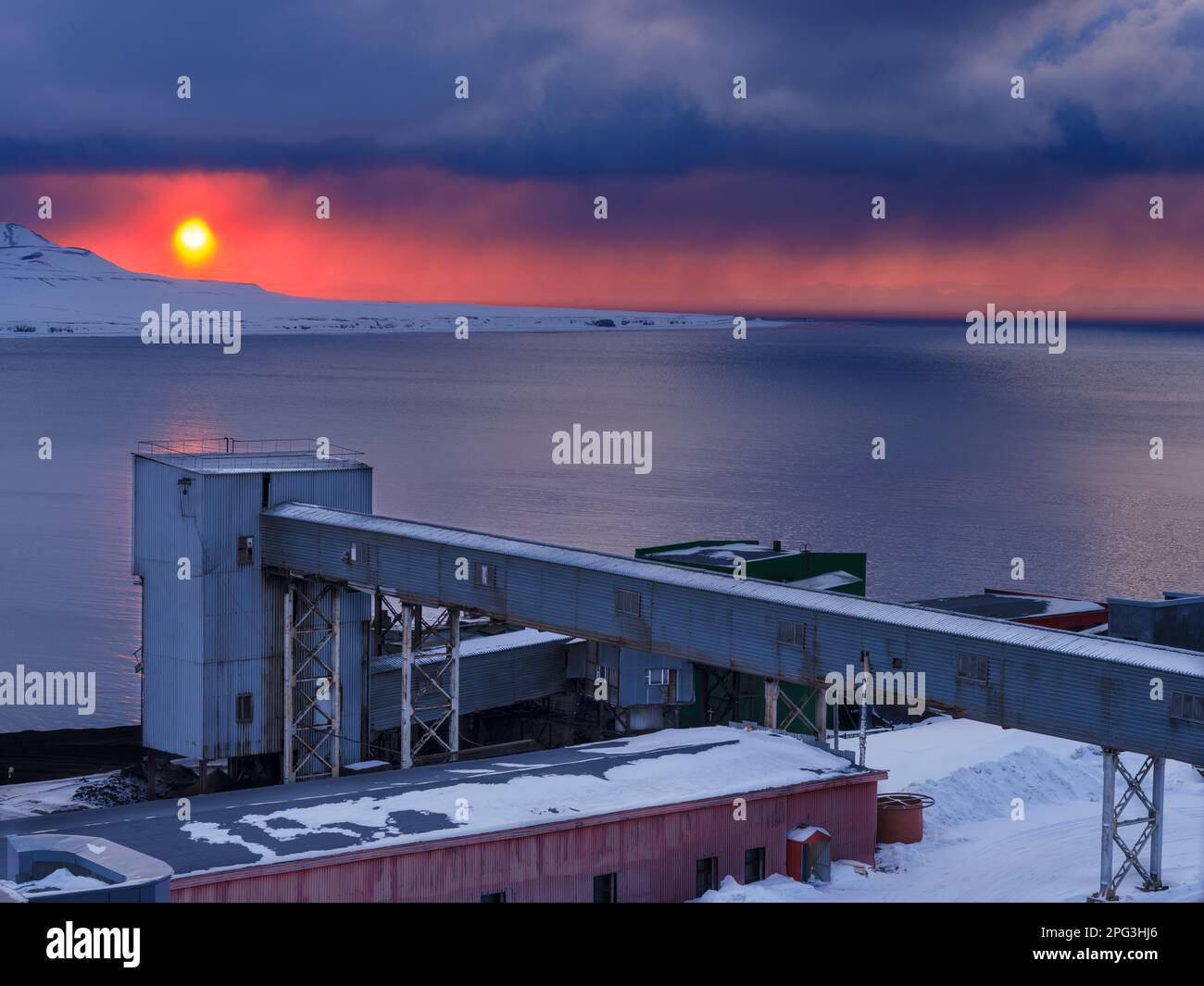 Sunset over the mine. Russian coal mining town Barentsburg at fjord ...