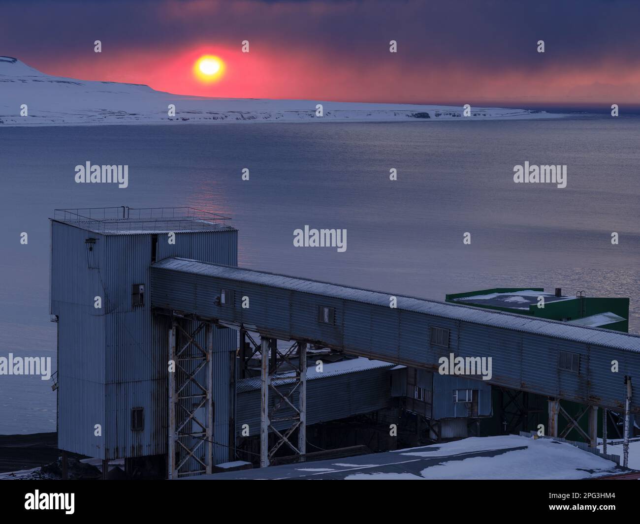 Sunset over the mine. Russian coal mining town Barentsburg at fjord ...