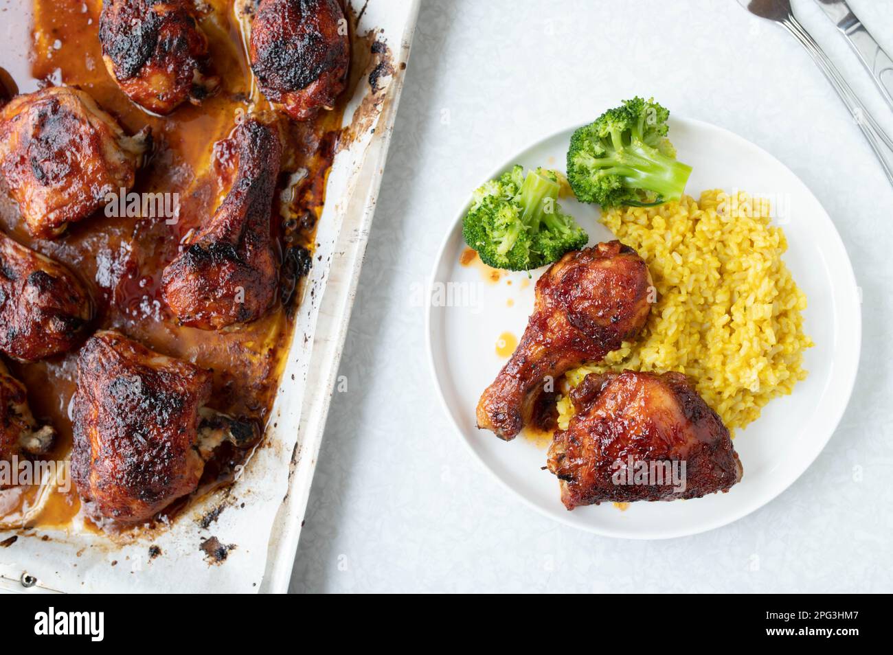 Baked and glazed barbecue chicken with pilau rice and broccoli on plate ...