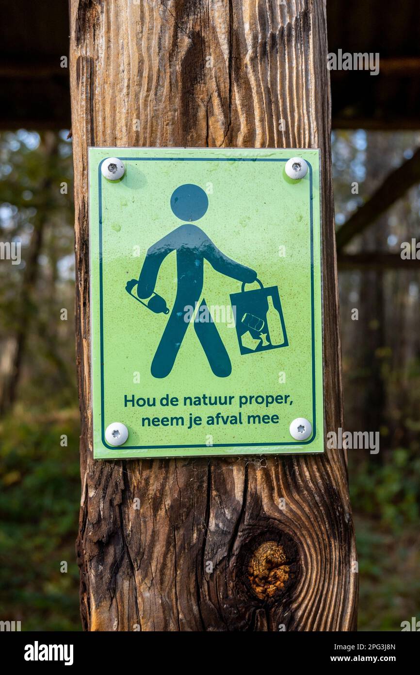 A green sign with text indicating "keep nature clean, take your waste ...