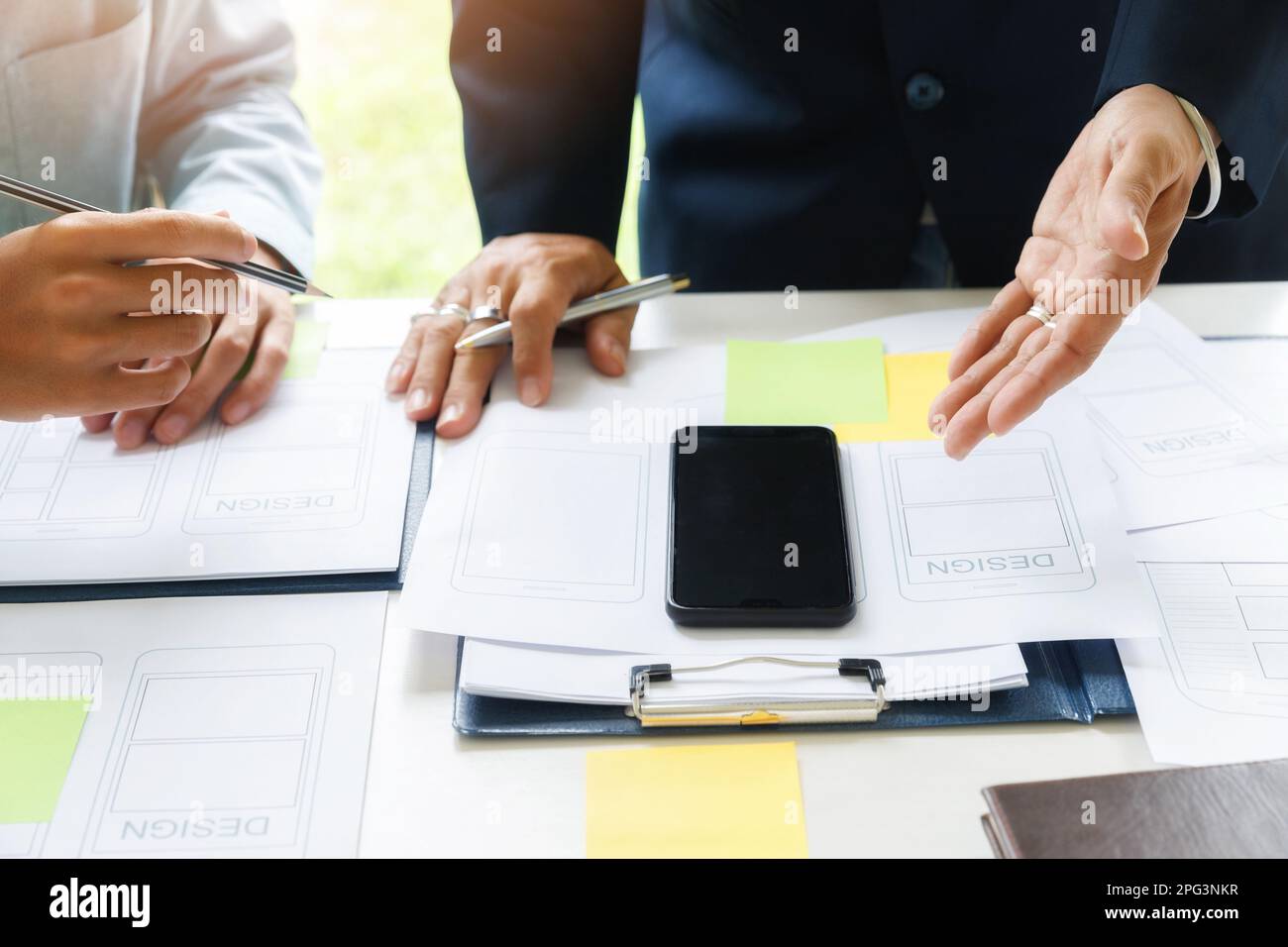 UX or UI designers designing on their smartphone application layout ...