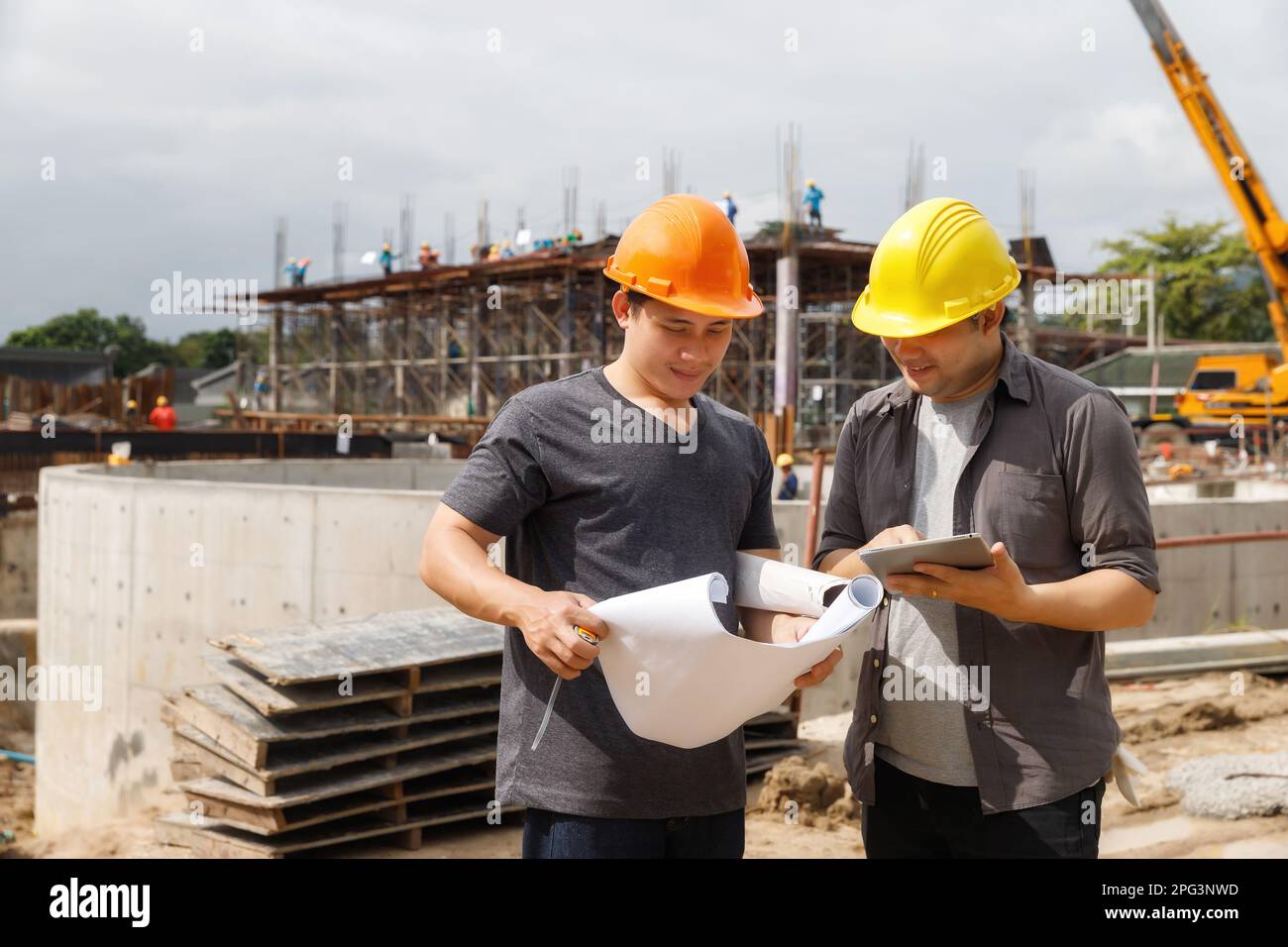 Team of construction workers discussing project details with blueprint ...