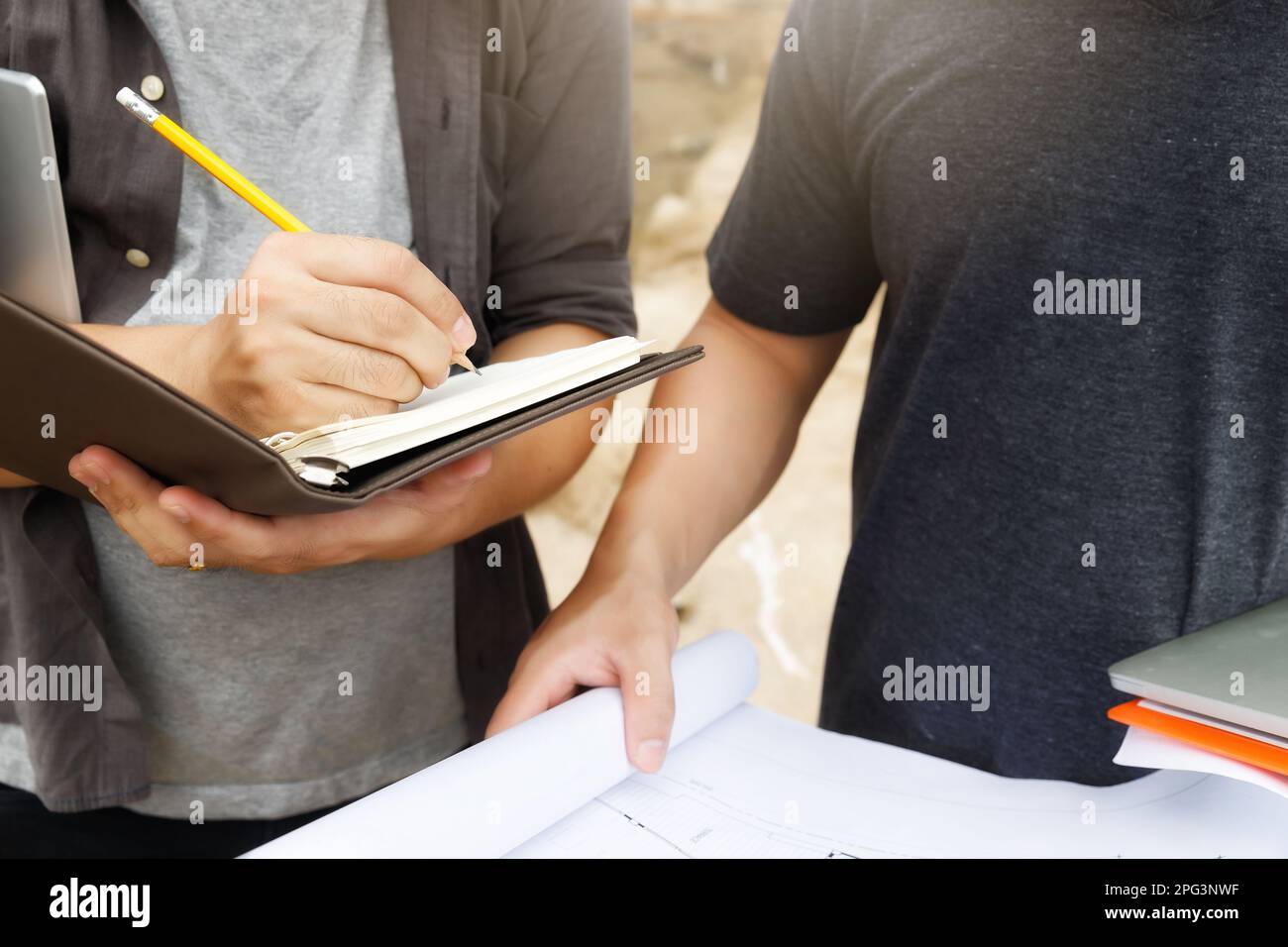 Team of construction workers discussing project details with blueprint ...