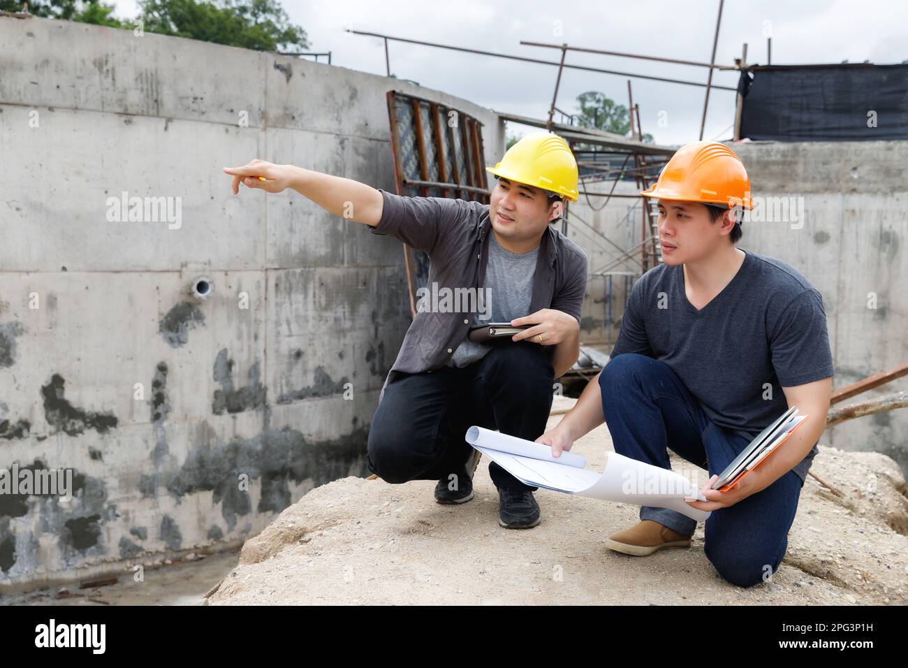 Team of construction workers discussing project details with blueprint ...